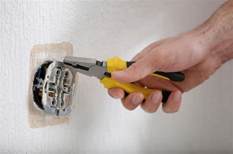 Premium Photo Hands Of Electrician Installing Socket Closeup