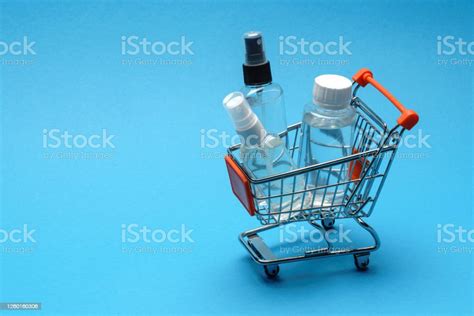 코로나 바이러스 보호 위생 개념 파란색 배경에 쇼핑 카트 트롤리에서 알코올 손 소독제 액체 바구니에 핸드 워시 0명에 대한 스톡