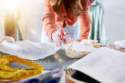 패션 디자이너 및 작업장에서 직물 절단 드레스 제작 및 의류 제조를 위해 가위로 일하는 여성 의류 디자이너 및 측정 테이프와