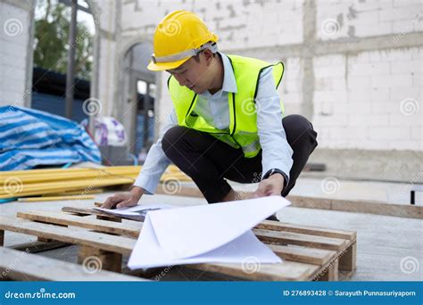Young Asian Engineer In Engineering Uniform And Helmet At Construction