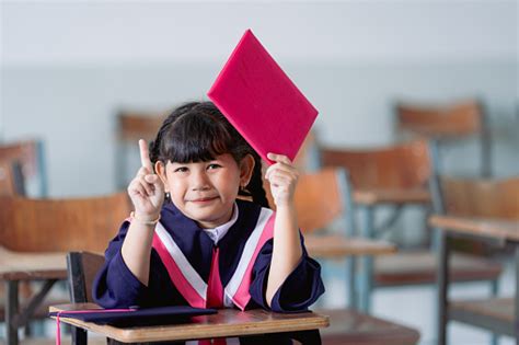 학업 가운과 졸업 모자를 쓴 쾌활한 아이 졸업생이 교실에서 졸업을 축하합니다 6 7 살에 대한 스톡 사진 및 기타 이미지 6 7 살 고등학교 이하 공부 Istock