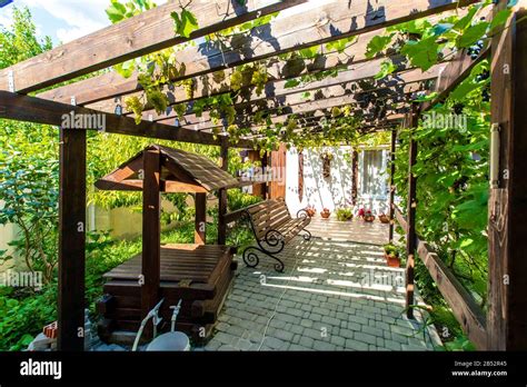 The Back Yard Of The Cottage With A Wooden Canopy Made Of Beams