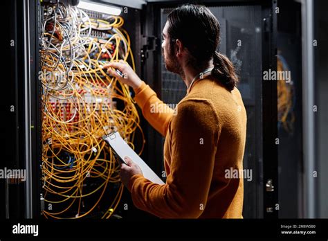 Side View Portrait Of Network Technician Working With Servers And