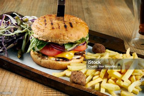 클래식 한 미국 패스트 푸드 소고기 커틀릿 토마토 체다 치즈를 곁들인 육즙이 가득한 버거와 샐러드와 감자 튀김의 반찬이 함께 있습니다 길거리 음식 0명에 대한 스톡 사진 및