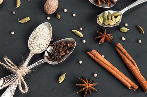 금속 빈티지 숟가락과 어두운 소박한 배경에 계 피 막대기에 다양 한 향신료 카 다 몬 흰 후추 육 두 구 아니 스 정 향 참 깨 향기로운 음식 요리와 재료를 베이킹입니다 0