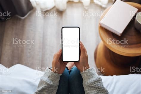 집에서 침대 방에 앉아있는 동안 빈 데스크톱 화면과 휴대 전화를 들고 여자 가정의 방에 대한 스톡 사진 및 기타 이미지