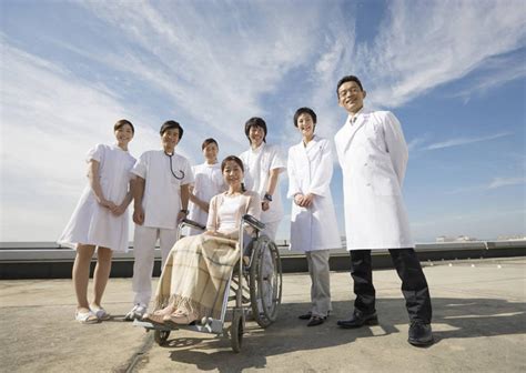 东方人医生护士站坐笑微笑露齿笑横图室外白天仰视工作服制服帽子纺织品亚洲握阴影装饰时间光线工具毛毯