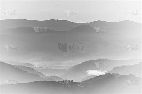 在日出时山顶上的美丽风景的阳光远处群山层峦叠嶂烟雾缭绕黑白风景高键摄影背景