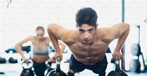 근력 운동을 하는 아름다운 젊은 부부 현대 체육관에서 케틀벨에 팔굽혀펴기를 하고 있다 사진 Unsplash의 슬로바키아 이미지