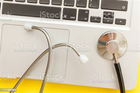 청진 기 키보드 노트북 컴퓨터 노란색 배경에 고립 현대 의료 정보 기술 및 Sofware 진보 개념 컴퓨터 및 가젯 진단 및