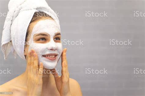 얼굴에 목욕 수건 및 크림 마스크와 함께 포장 매력적인 젊은 여자 가꿔주기에 대한 스톡 사진 및 기타 이미지 가꿔주기 개념 개념과 주제 Istock