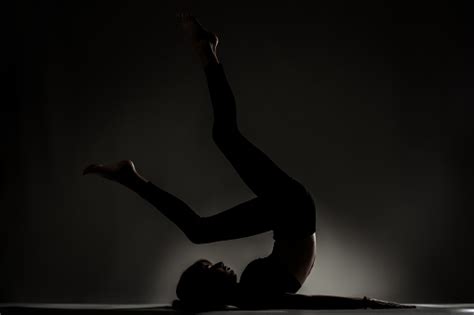 발레리나 소녀가 누워 스트레칭을 연습하고 요가 포즈를 취하십시오 어두운 배경에 측면 조명 실루엣 16 17 살에 대한 스톡 사진