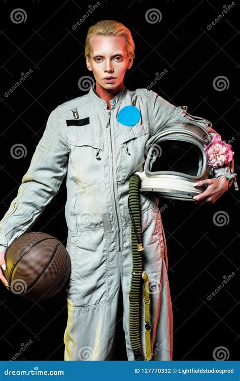 Astronauta De Sexo Femenino Atractivo En El Spacesuit Que Sostiene Baloncesto Y El Casco Con La
