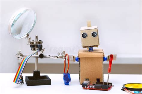 the robot with hands is on the table and next to it are parts for assembling the robot stock