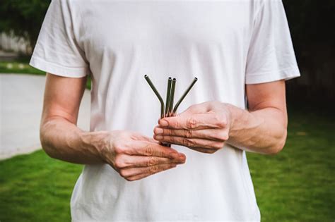 재사용 가능한 강철 마시는 빨대를 들고 흰색 티셔츠를 입은 남자 에코 라이프 스타일과 제로 폐기물 개념 플라스틱 프리 0에 대한