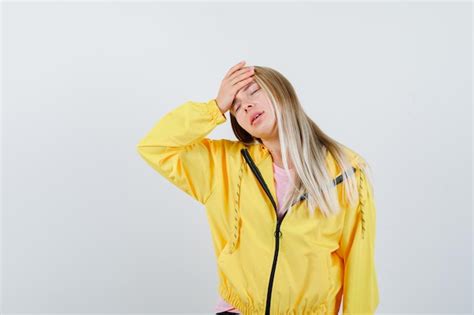Free Photo Blonde Girl Holding Hand On Forehead In Yellow Jacket And