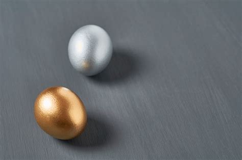 어두운 콘크리트 배경에 황금과 은색 계란 부활절의 개념 귀중한 아이디어 성공적인 비즈니스 투자 또는 고급 아침 식사 복사 공간
