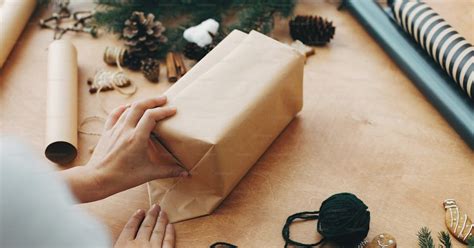 공예 종이와 소나무 가지 콘 진저 브레드 쿠키 실 시골 나무 테이블에 계피로 크리스마스 선물을 포장하는 손 세련 된 크리스마스 선물 컨셉을 포장 사진