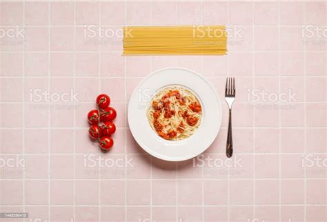 포크 근처의 흰색 접시에 고기가 있는 파스타와 분홍색 배경에 체리 토마토의 상위 뷰 플랫 레이에 대한 스톡 사진 및 기타 이미지