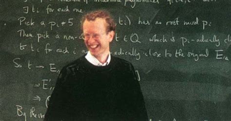 A Man Standing In Front Of A Blackboard With Writing On It