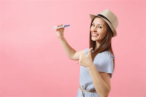 파란 드레스에 흥분된 행복 한 여자 모자 잡고 손 임신 테스트 분홍색 바탕에 고립 된 보고 의료 의료 부인과 임신 임신 출산