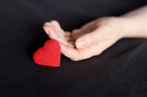 검은 침구가있는 침대에 빨간 뜨개질 된 심장과 여성의 손 개념에 대한 스톡 사진 및 기타 이미지 개념 건강관리와 의술