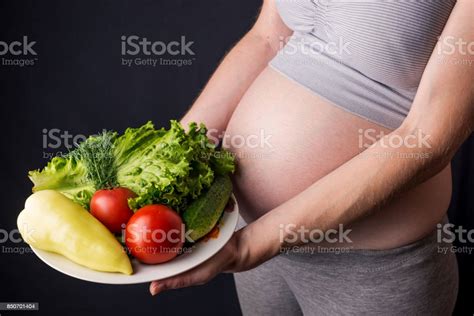 야채와 함께 접시를 들고 임신한 여자 배입니다 체중 조절 및 임신 중 건강 한 식 생활에 대 한 개념 건강한 생활방식에 대한