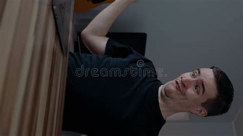 Vertical Of Expressive Man Does Funny Body Movements Sitting At Table