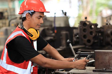중공업 제조 공장에서 안전모로 작업을 제어하거나 산업 기계 프로세스를 확인하는 동안 보호 유니폼을 입고 컴퓨터를 사용하는 기술자 엔지니어 또는 작업자 35 39세에 대한