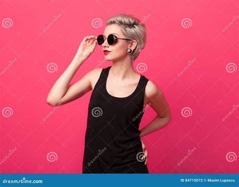 Young Attractive Woman Wearing Round Sunglasses Over Pink Color