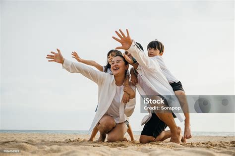 해변에서 휴가를 보내는 즐거운 가족 아이를 데리고 웃고 놀고 햇볕을 즐기는 부모들 여름 휴가는 행복 재미 및 자유를 묘사합니다 여행과 가족의 즐거움 남성에 대한 스톡 사진