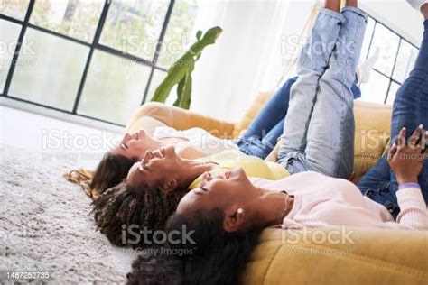 세 명의 행복한 여자가 소파 집에서 함께 웃고 즐거운 시간을 보내고 있다 웃는 여자 친구 실내 생활 3 명에 대한 스톡 사진 및