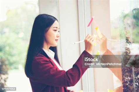 젊은 아시아 사업가 쓰기 작업 창조적 인 아이디어와 유리 벽에 메모 끈적 끈적한 게시물에 계획프로젝트 전략 계획은 유리 스크럼 보드 사무실 벽에 노트 스티커 게시물에 대상