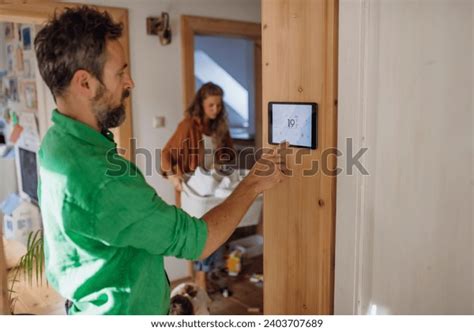 Man Adjusting Temperature Through Home Automation Stock Photo