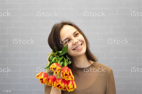 밝은 배경에 손에 꽃 튤립과 갈색 드레스에 아름 다운 소녀 3월에 대한 스톡 사진 및 기타 이미지 3월 8 공휴일 Istock