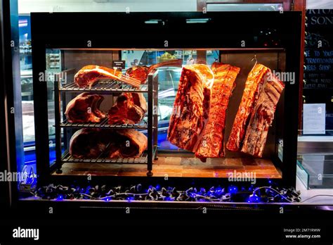 Cuts Of Meat In A Butchers Shop Window With Christmas Holly Lit Up At