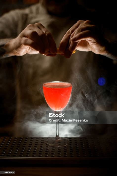 레몬 껍질을 들고 연기가 자욱한 바에서 칵테일과 함께 유리에 뿌려바텐더 바텐더에 대한 스톡 사진 및 기타 이미지 바텐더 어두운 색 감귤류 과일 Istock