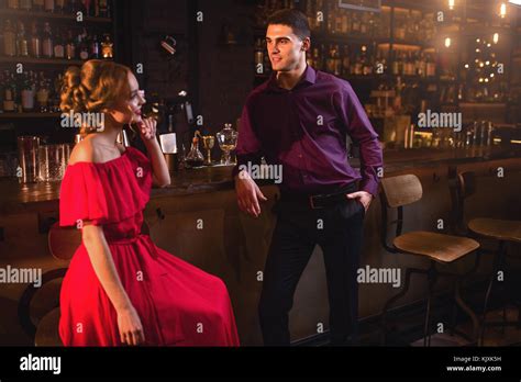 Acquaintance In Bar Beautiful Woman In Red Dress Flirts With Man