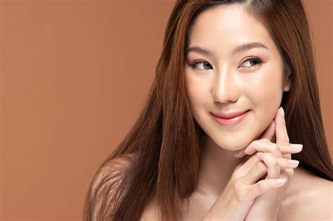 아름다운 아시아 젊은 여자 감동 부드러운 뺨 미소 와 깨끗 한 신선한 피부 행복과 쾌활 한 감정 베이지 배경에 고립 된 뷰티