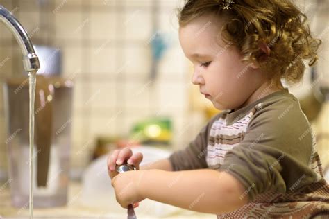 Premium Photo Sute Twoyear Girl Washes The Dishes