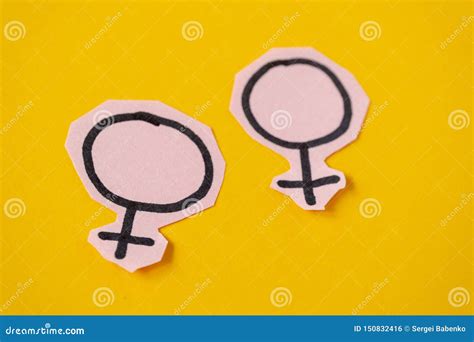 Two Gender Symbols Venus Cut From Pink Paper On Yellow Background