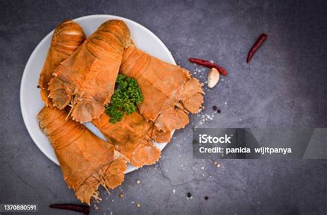 해산물 레스토랑에서 파슬리 로즈마리와 신선한 슬리퍼 랍스터 플랫 헤드 삶은 요리 흰색 접시와 해산물 소스에 제공되는 플랫 헤드 랍스터 새우 록 랍스터 모튼 베이 버그 갈고리