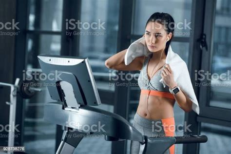 젊은 운동 Sportswoman 체육관에서 디딜 방 아에 조깅 후 수건으로 닦아 건강한 생활방식에 대한 스톡 사진 및 기타