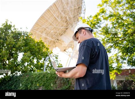 Engineer Testing Earth Based Astronomical Radio Telescope Use Laptop