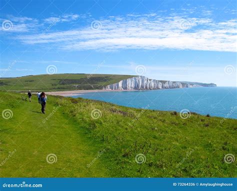 Hikers Approach White Cliffs Of Seven Sisters East Sussex England