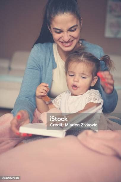 쾌활 한 어머니와 그녀의 작은 딸 집에서 바닥에 앉아 함께 책을 읽고 부모에 대한 스톡 사진 및 기타 이미지 부모 아이