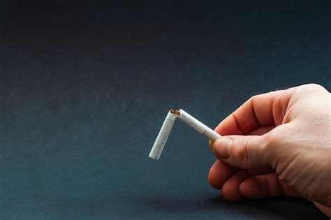 Pilha quebrada de cigarros na mão de uma mulher pare de fumar Foto Premium