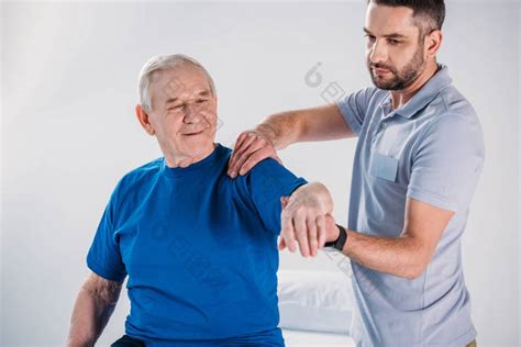 理疗师肖像按摩桌上的微笑老人按摩图片 包图网企业站