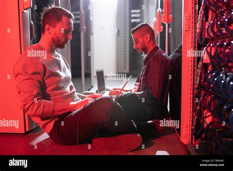 Concentrated Young Multi Ethnic Engineers Sitting On Floor In Server