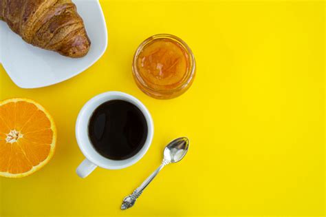 노란색 배경에 커피 오렌지 마멀레이드 크루아상과 함께 하는 유럽식 조식 맨 위 보기입니다 공간을 복사합니다 0명에 대한 스톡